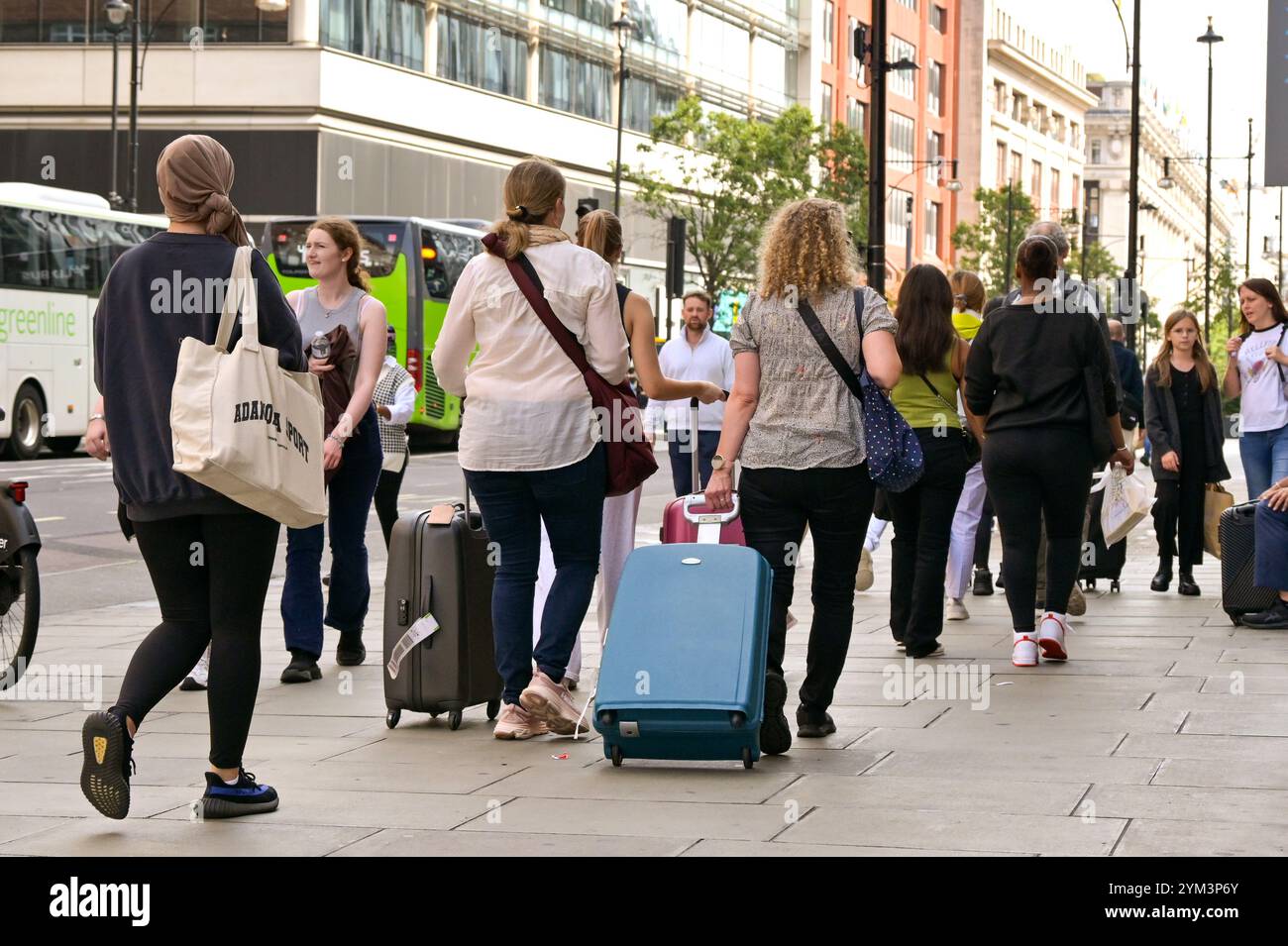 London, England, UK - 24 August 2023: Visitors to London pulling ...