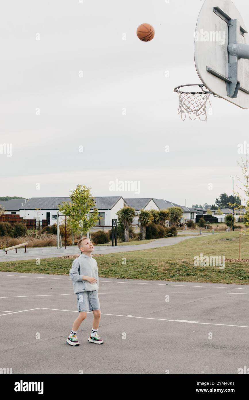 Teenage boy hits goal playing basketball on village sports ground Stock ...