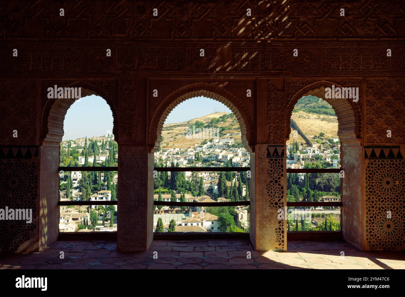 The ornate Moorish arches of Alhambra’s Partal Palace frame a hillside ...