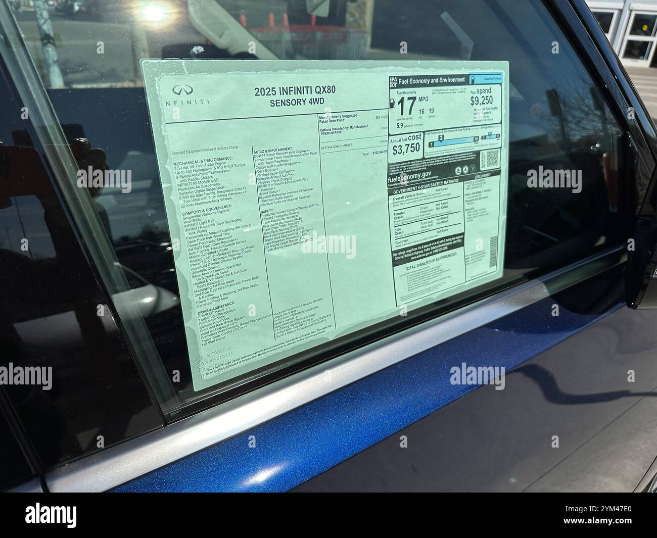 The window sticker for $102,680 is affixed to the front side window of ...