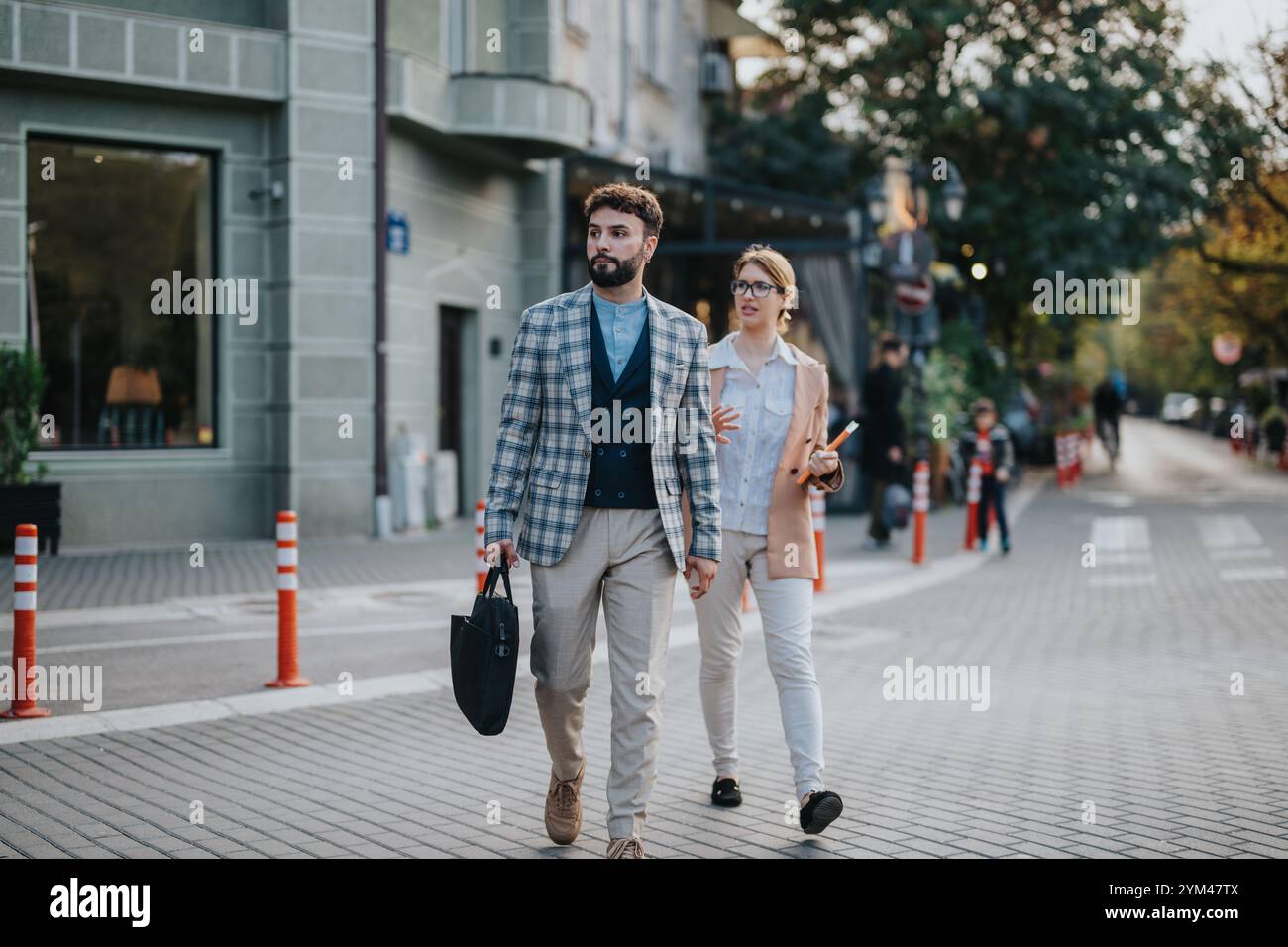 Professionally dressed business colleagues walking together in urban ...