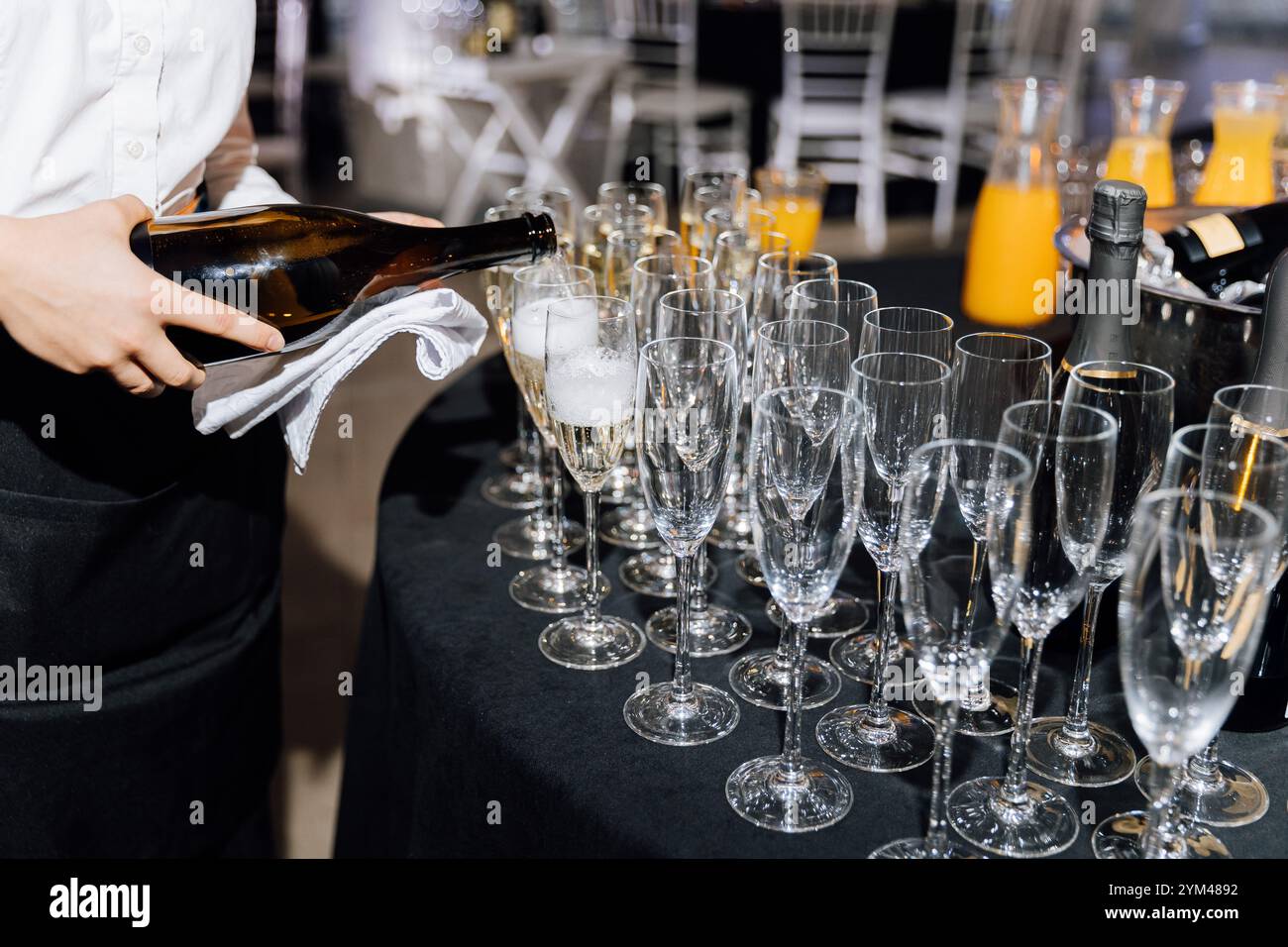 Elegant champagne pouring at a formal event with glasses prepared for ...