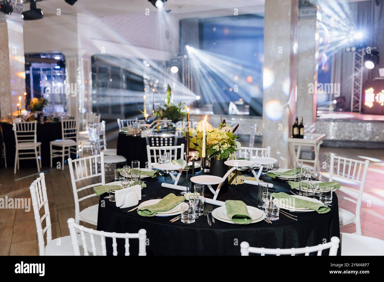 Elegant banquet hall setup with floral centerpieces, candles, and stylish table arrangements ...