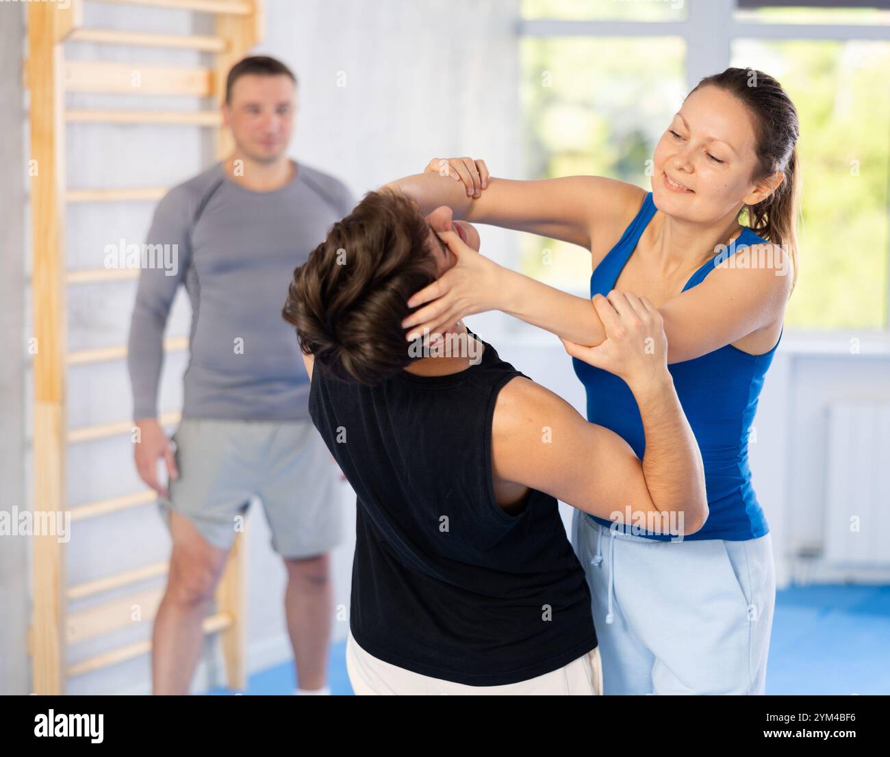 Self-defense class - woman makes painful hold in eyes of an attacking ...