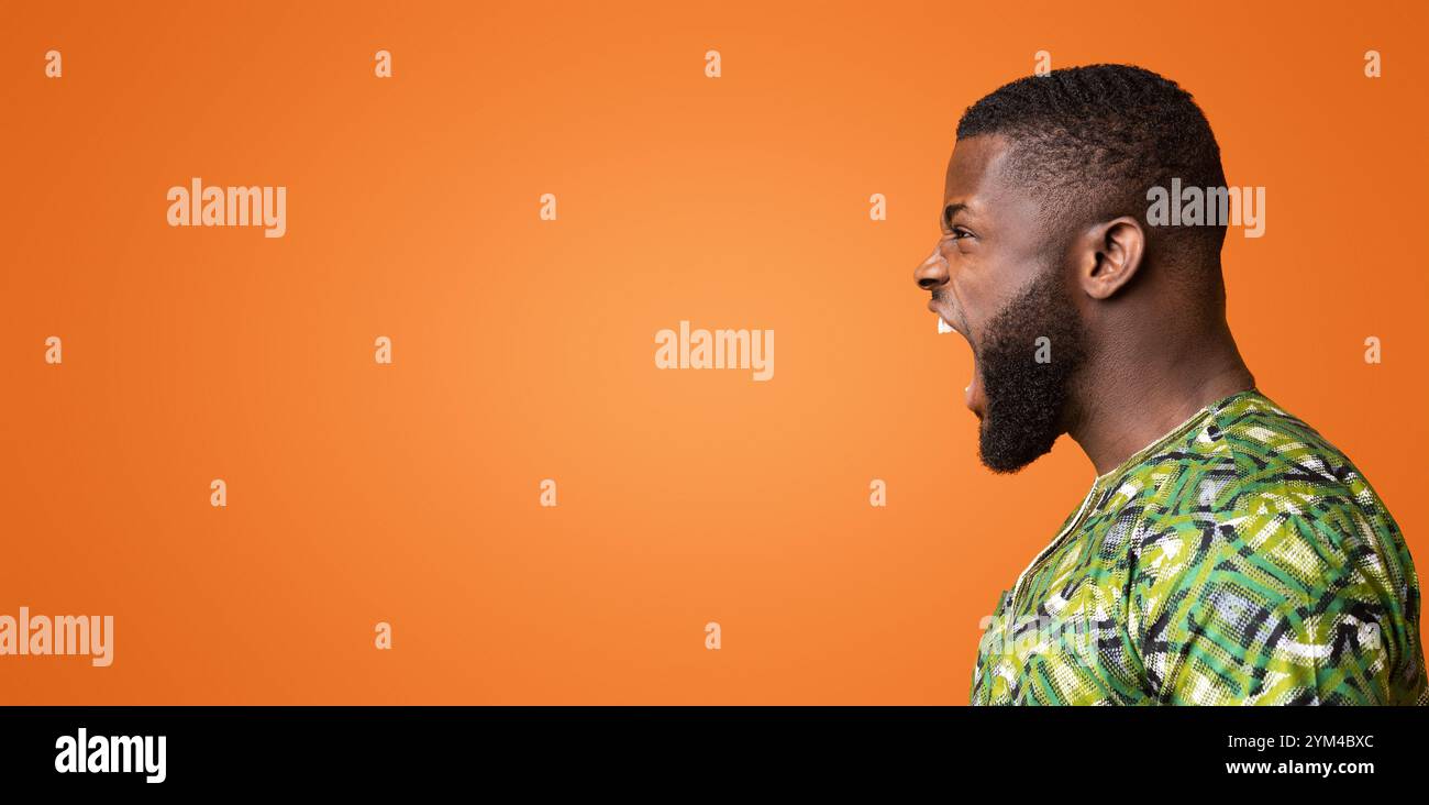 Side view of angry black guy shouting towards copy space Stock Photo ...