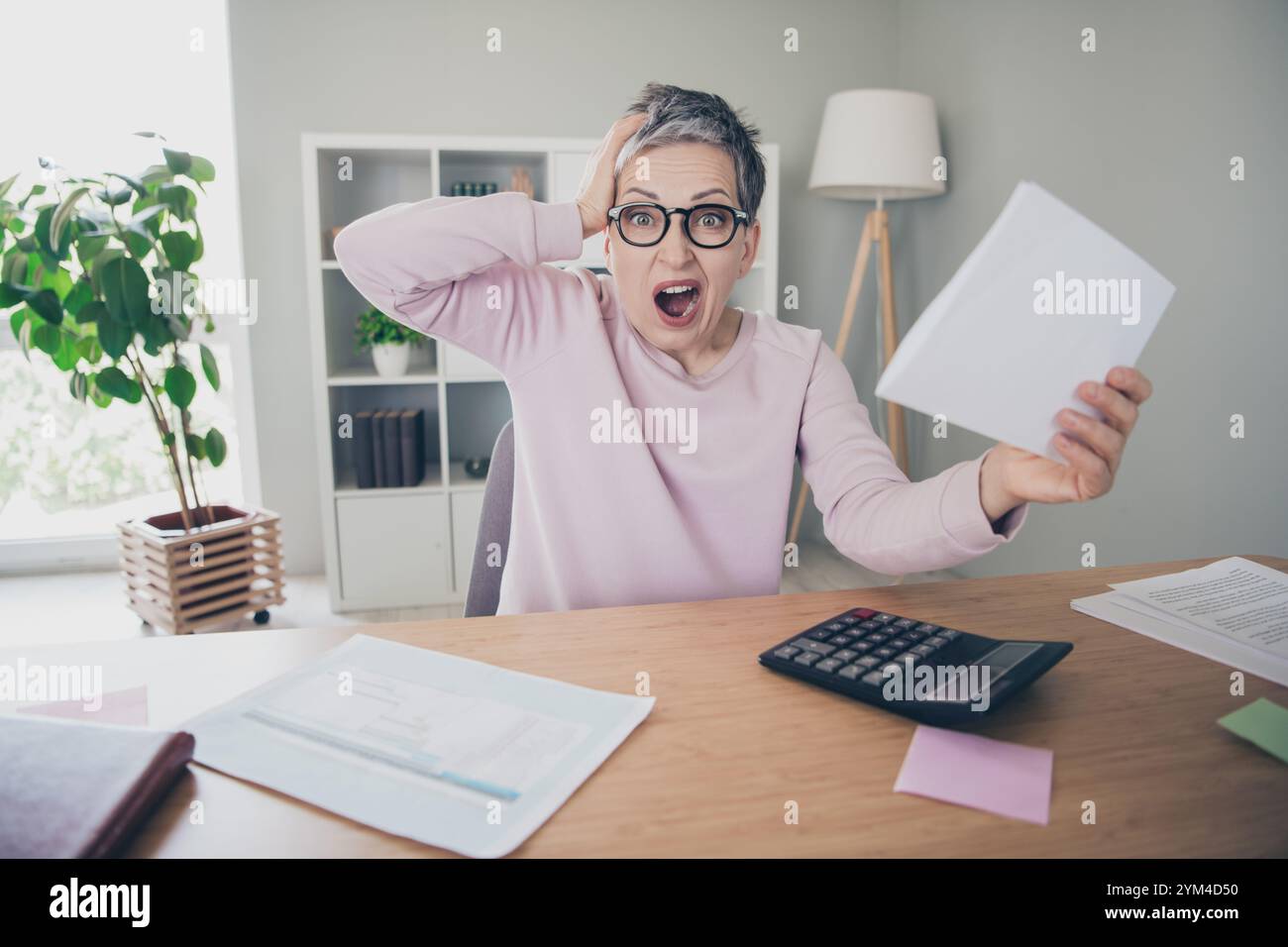 Photo of angry shocked lady wear pink sweatshirt counting calculator ...