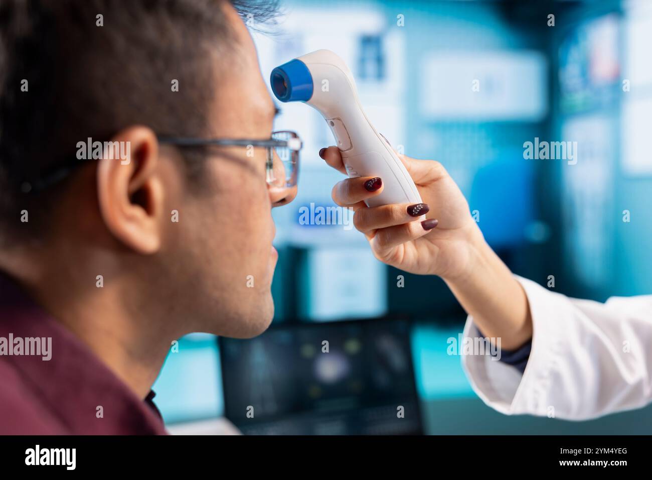 Healthcare expert uses a digital thermometer to check for fever and flu symptoms, professional ...