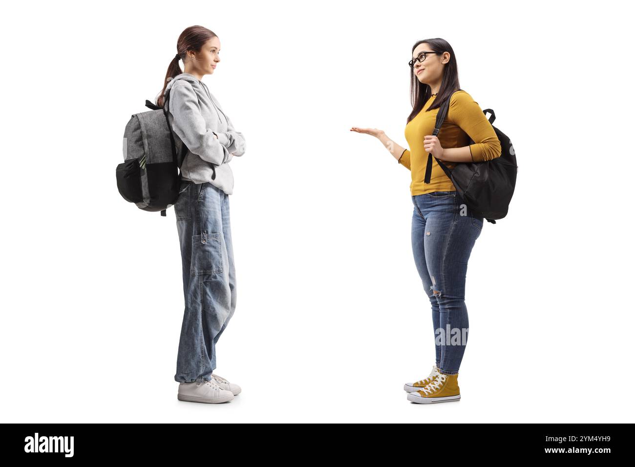 Full length profile shot of two female students having a conversation ...