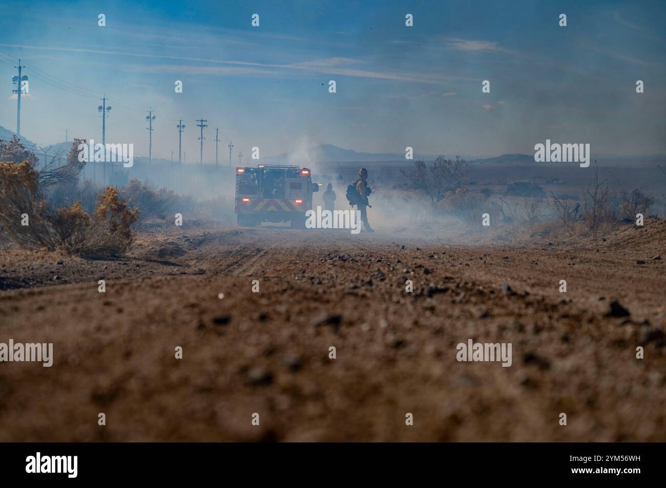 Kirtland Air Force Base firefighter watches vegetation burn during a ...