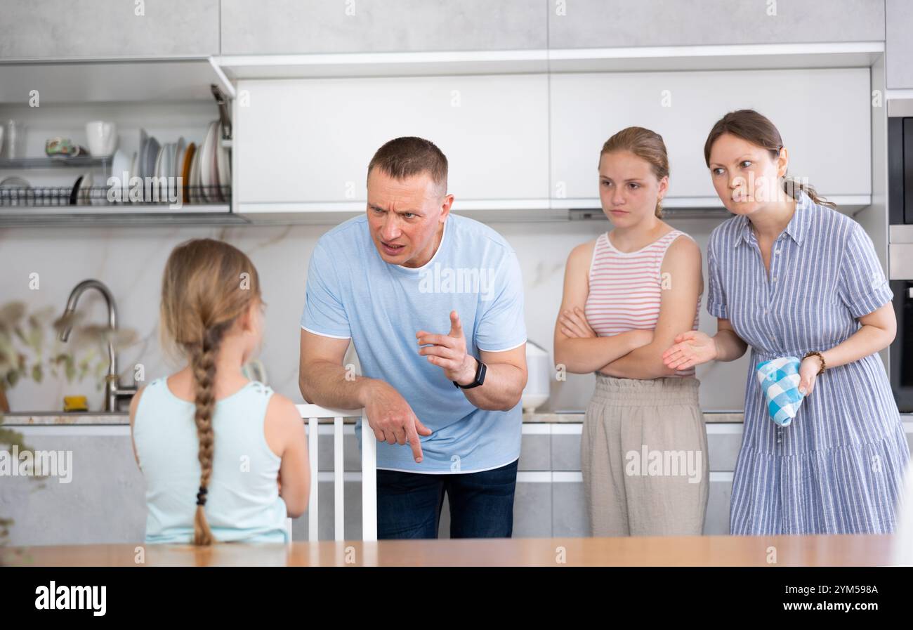 Preteen girl listening to disapproving words of father, mother and ...