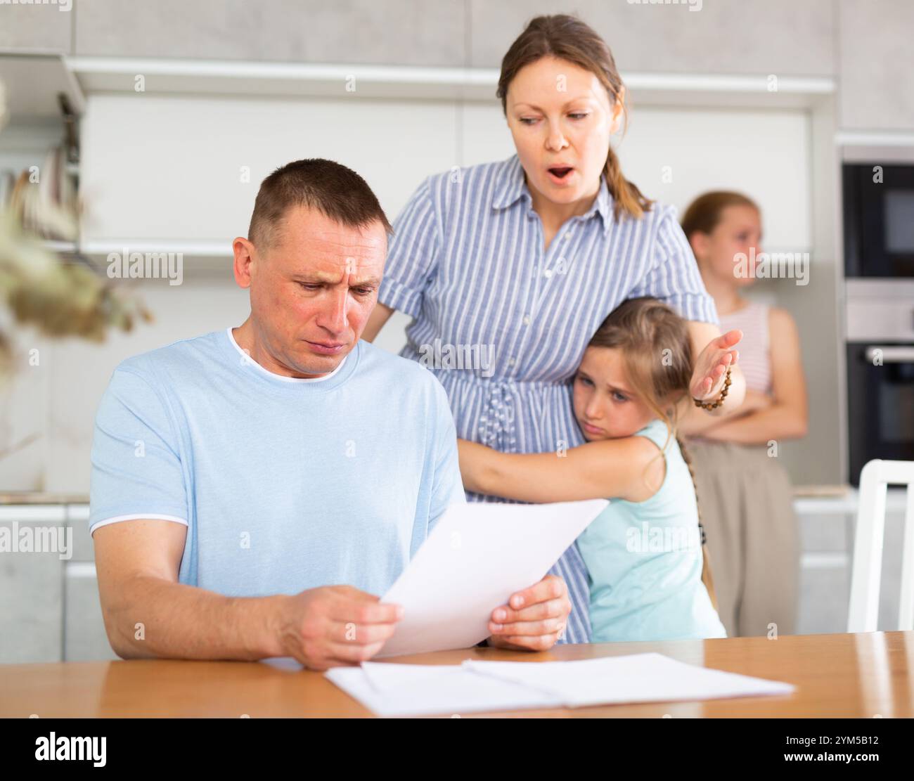 Wife yells at her husband who has not paid the loan. Children upset and ...