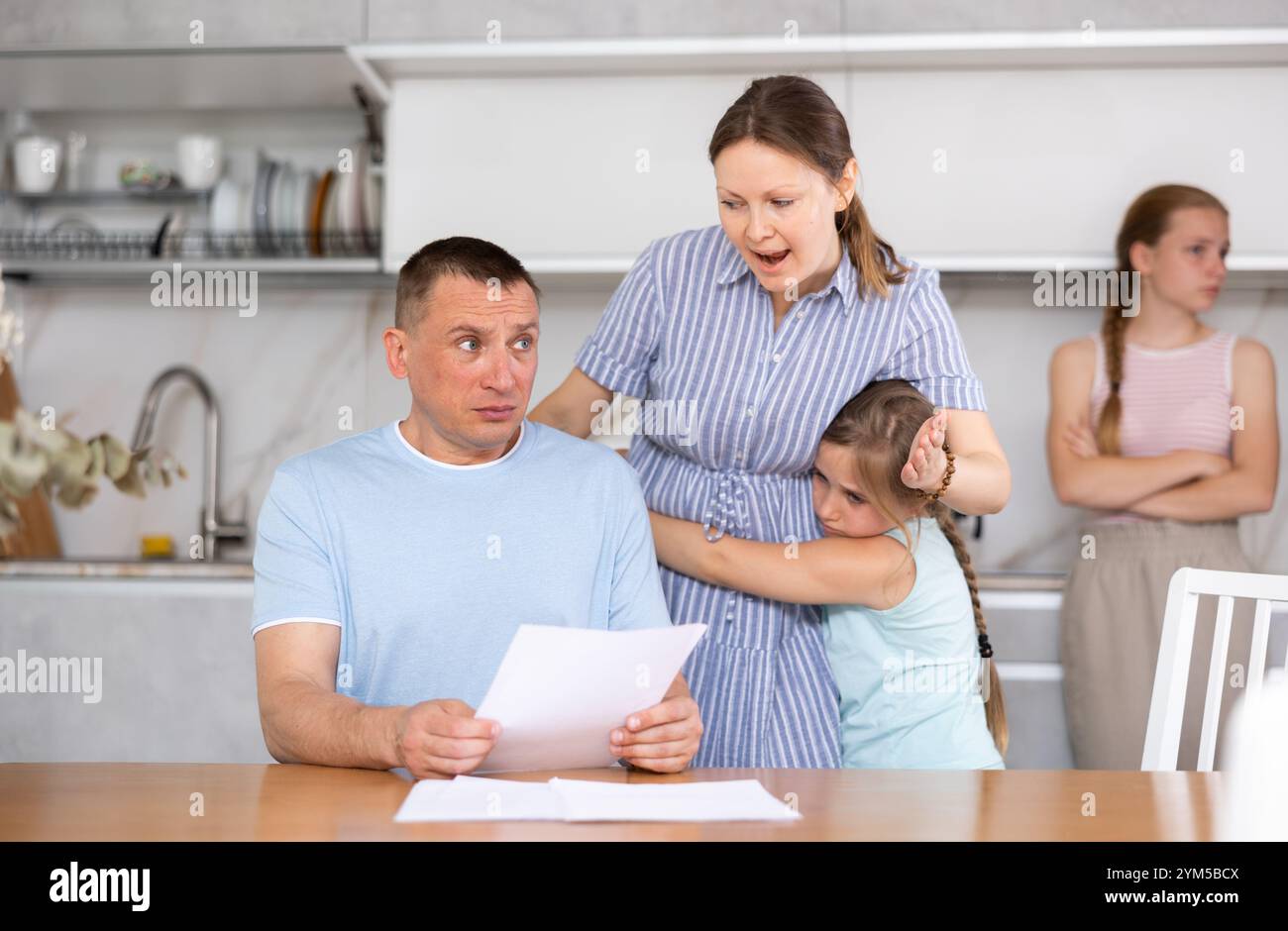 Wife yells at her husband who has not paid the loan. Children upset and ...
