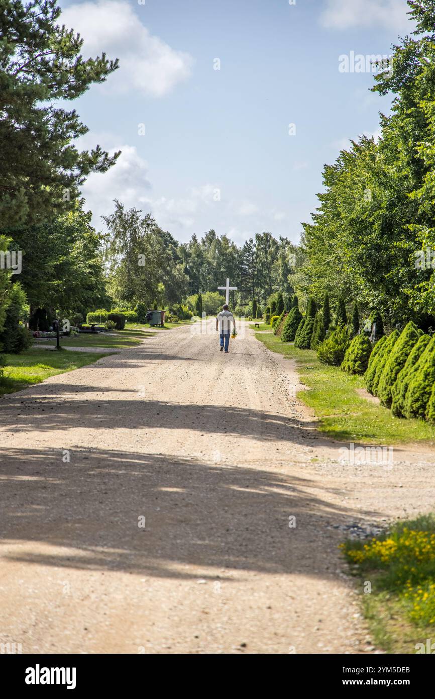 Sad man with flowers visiting loved ones at graveyard Stock Photo - Alamy