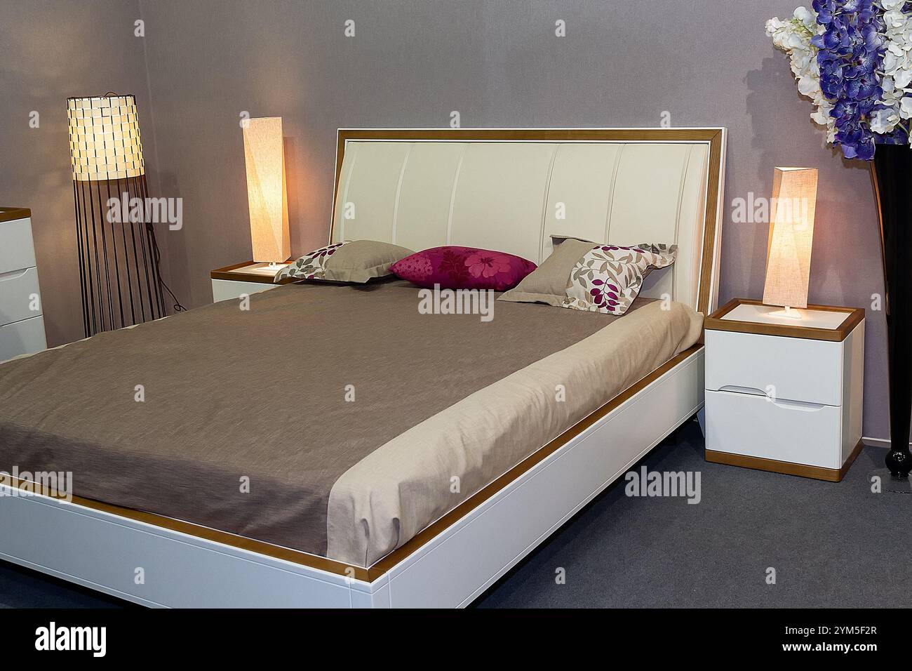 Modern bedroom with a pastel color palette, chic bed linens, and lamps ...