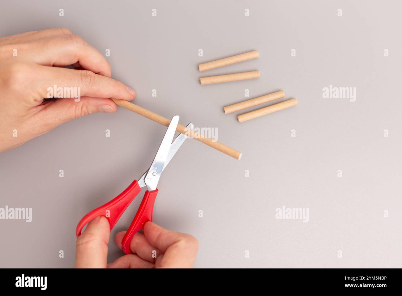 Hand with scissors cutting paper straw step in DIY project quick ...