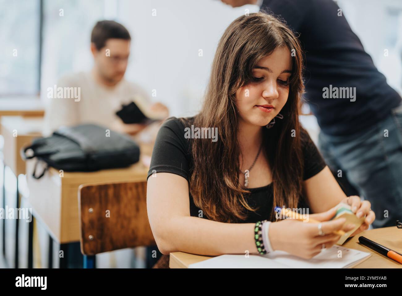 Focused high school student takes notes in classroom setting Stock ...