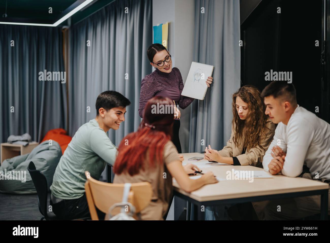 Art teacher guiding students during a creative drawing class Stock ...
