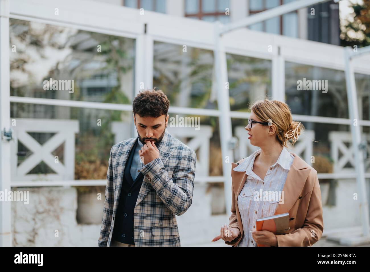 Two people engage in conversation outdoors in business attire Stock ...