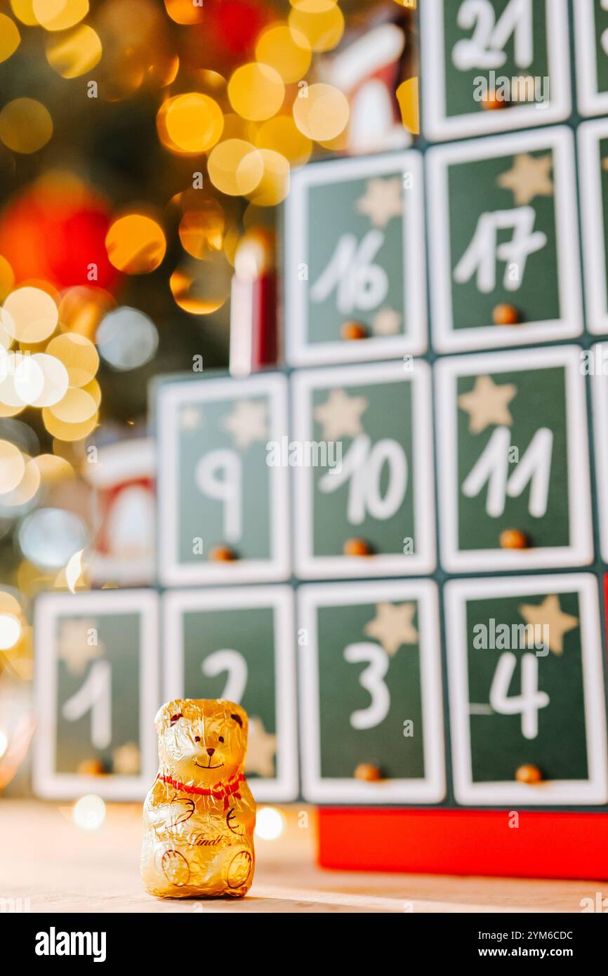 Chocolate bear in gold foil row with advent calendar on Christmas tree ...