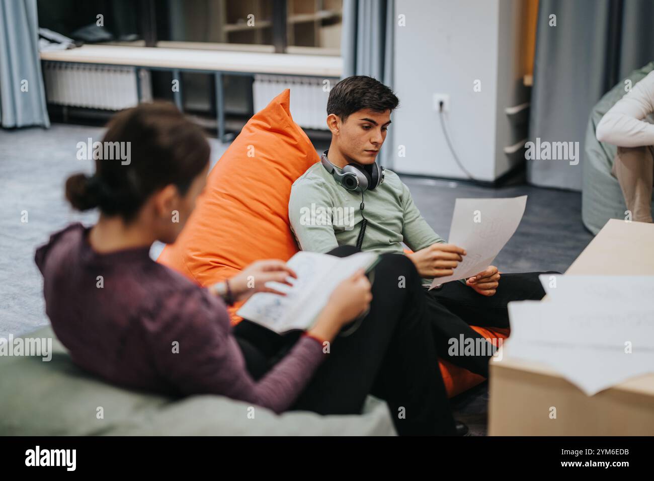 Students sitting in a modern classroom, engaged in studying and reading ...