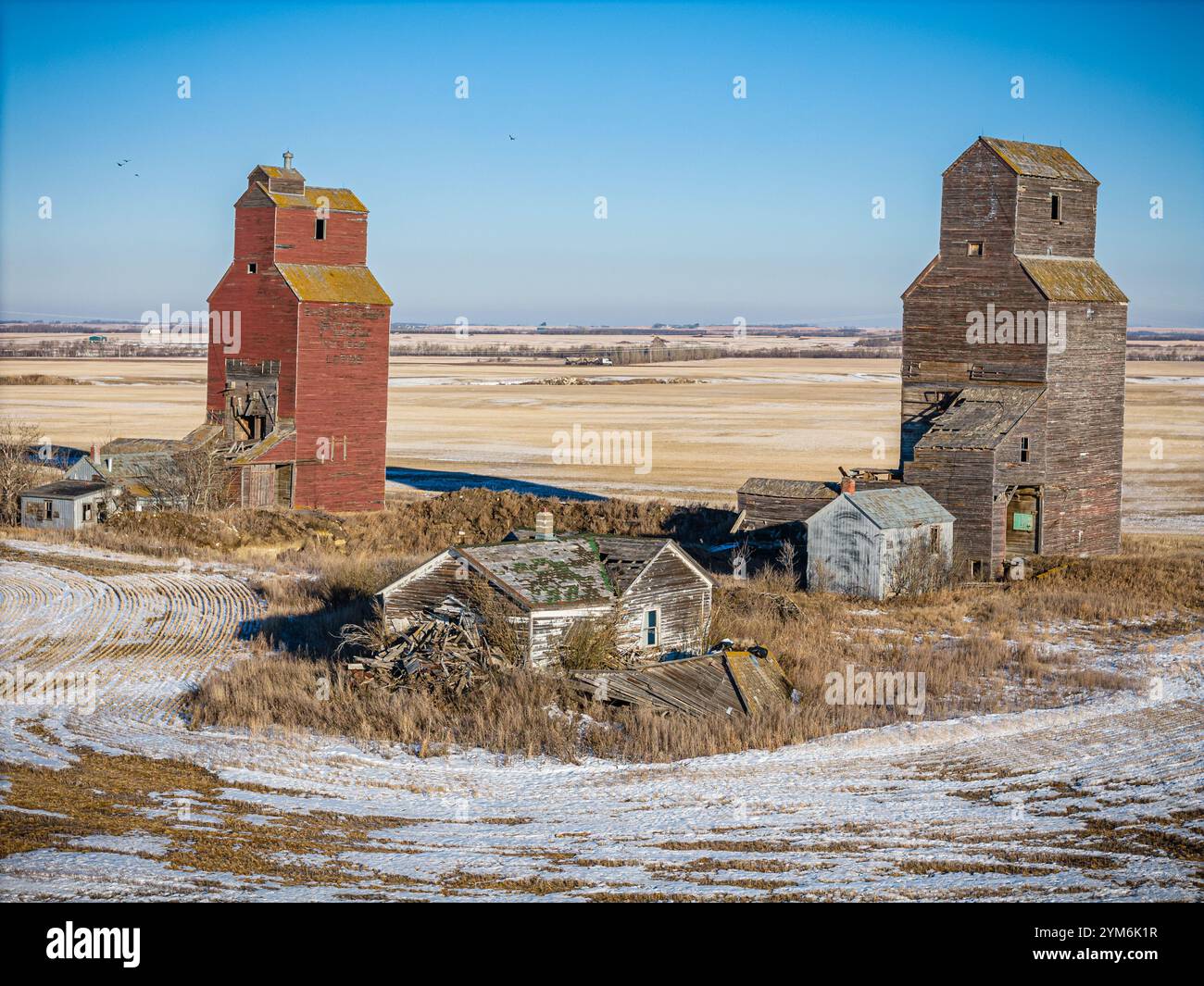 A rural scene with two red grain silos and a small house. The houses ...