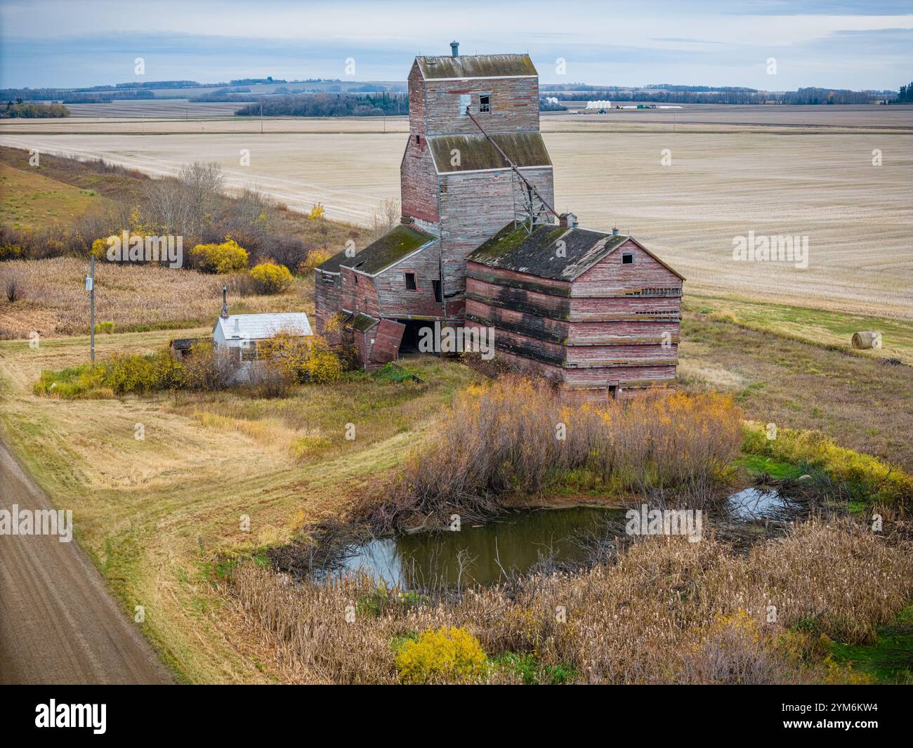 A farm with a barn and a house. The barn is old and the house is also ...