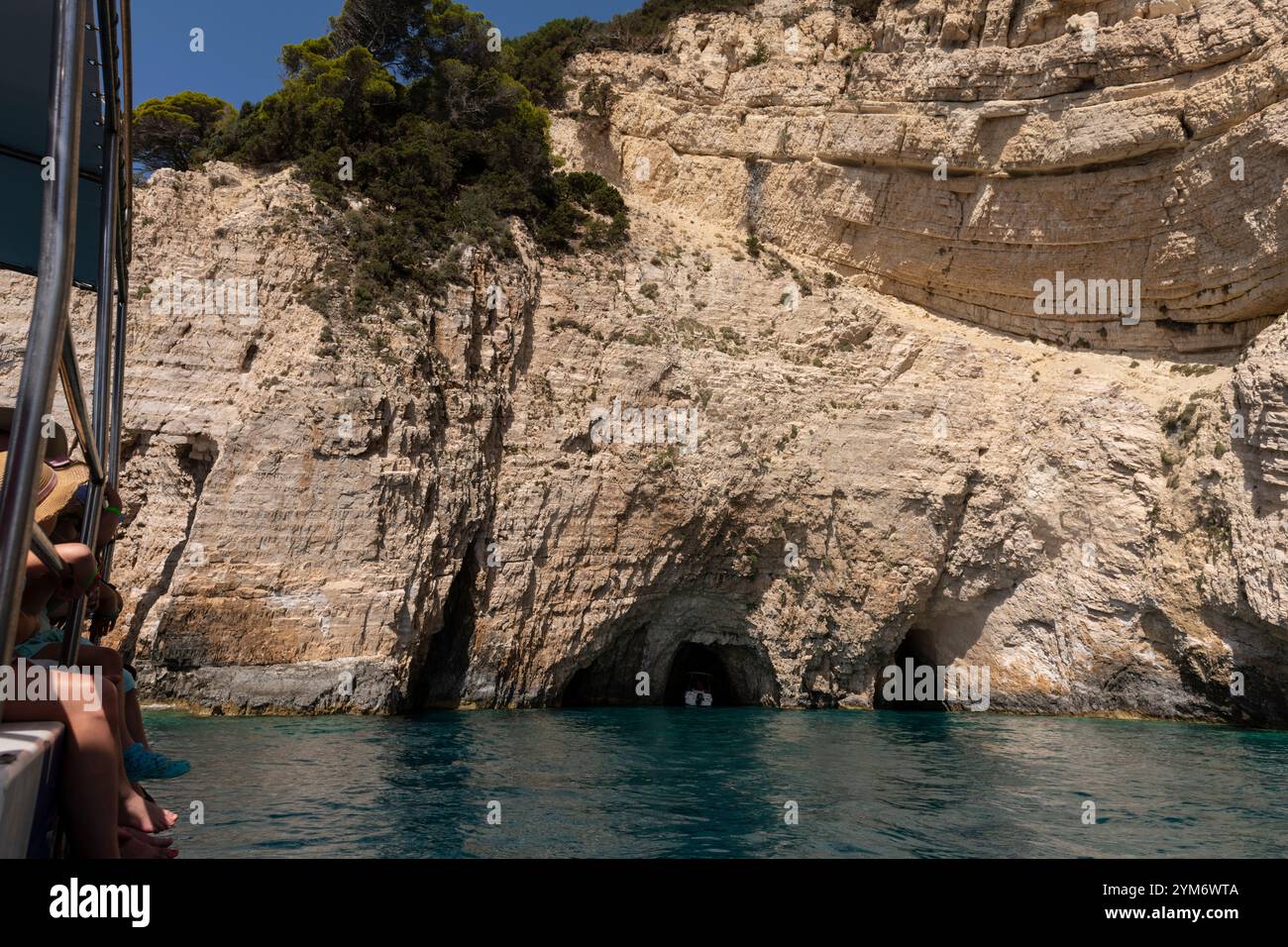 A close view of passengers on a boat tour near the sea caves of ...