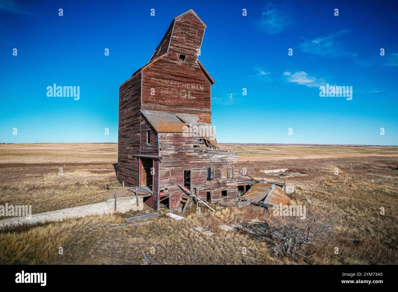 A large, old, abandoned building with a slanted roof. The building is ...