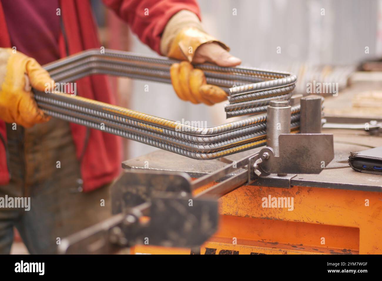 A skilled craftsman meticulously shaping metal using a clamp, set in a ...