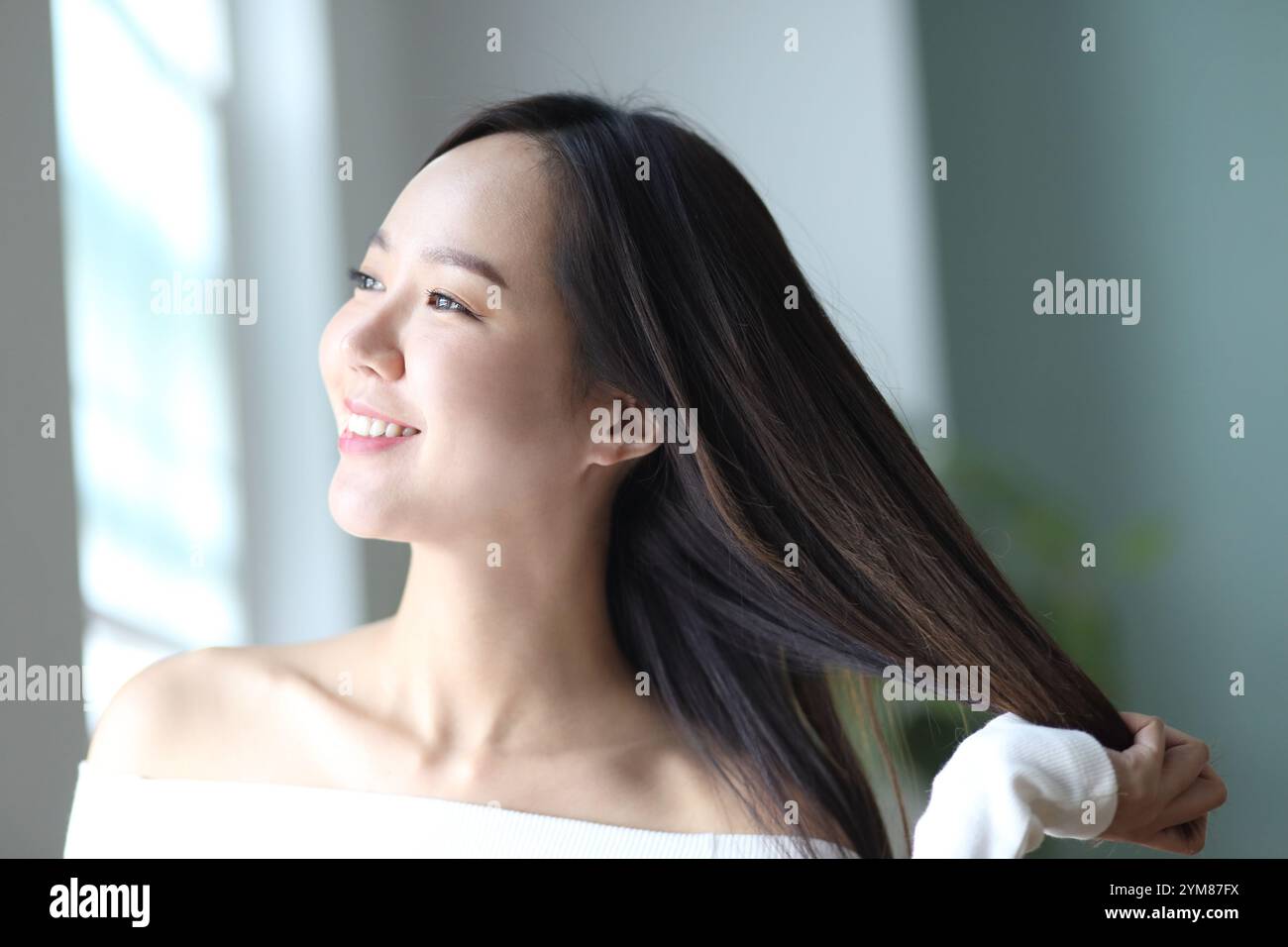 Woman looking out of glass window with a smile Stock Photo - Alamy