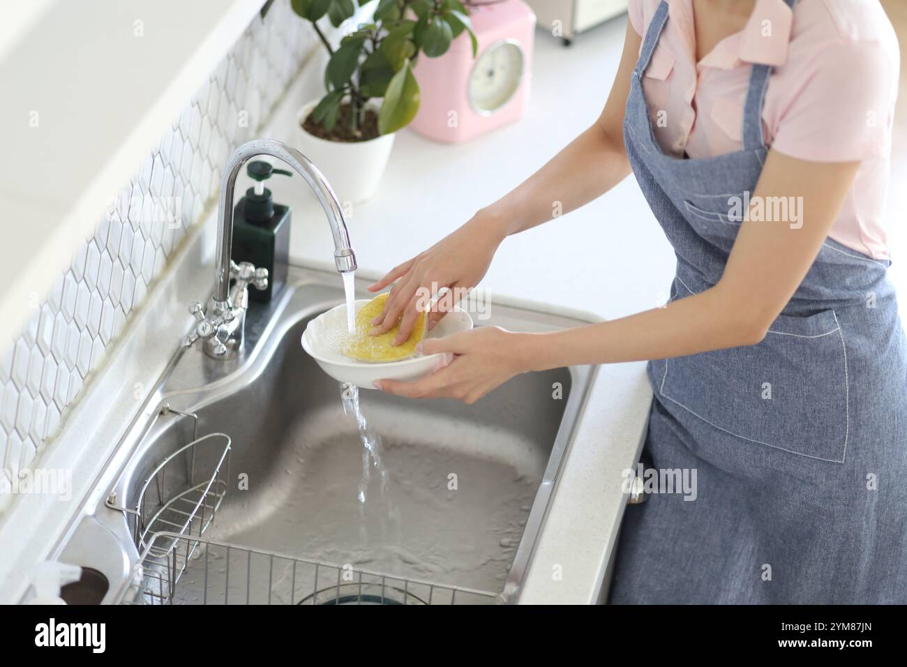 Woman washing utensils hi-res stock photography and images - Alamy