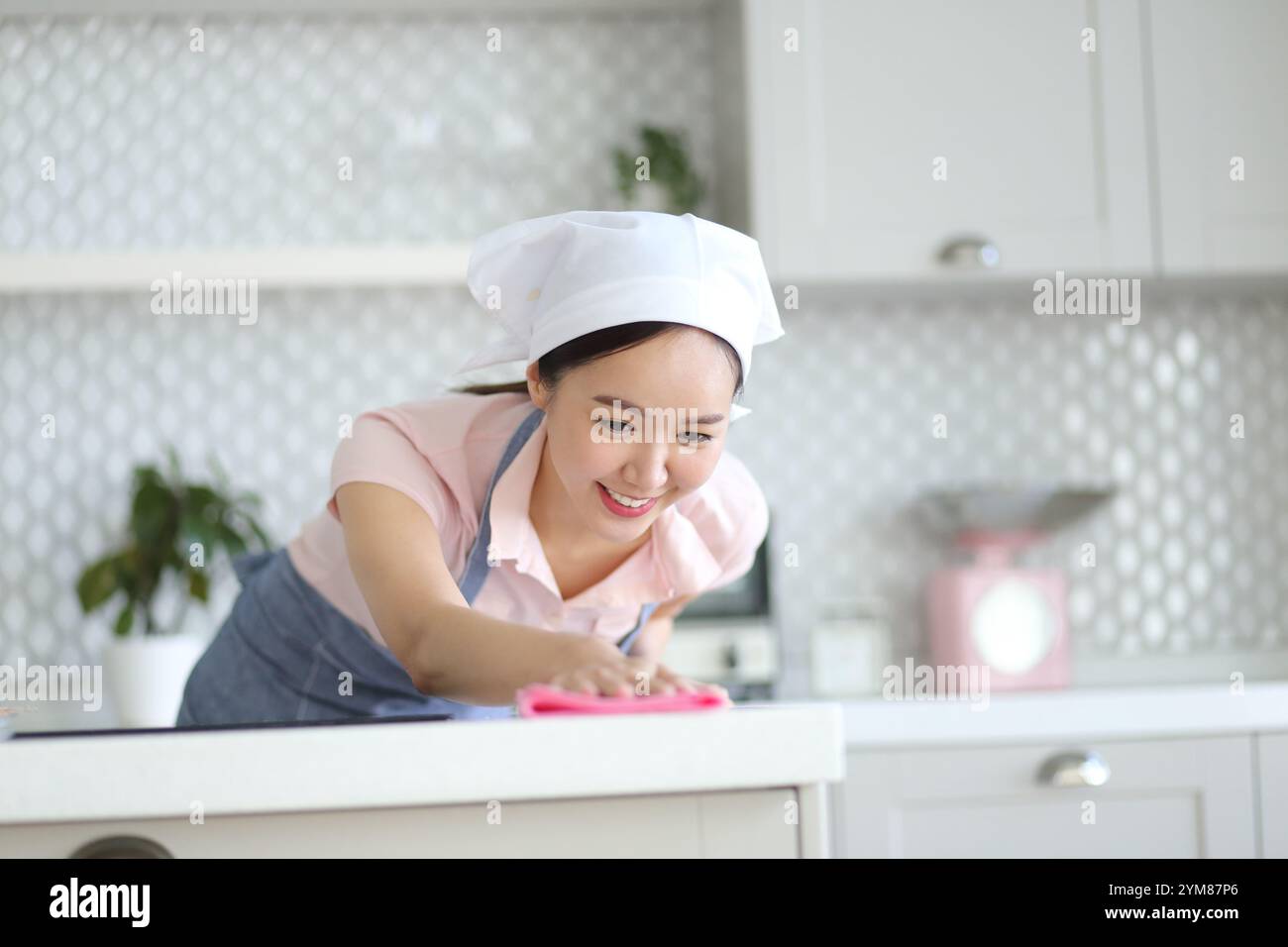 Image of young housewife cleaning the kitchen Stock Photo - Alamy