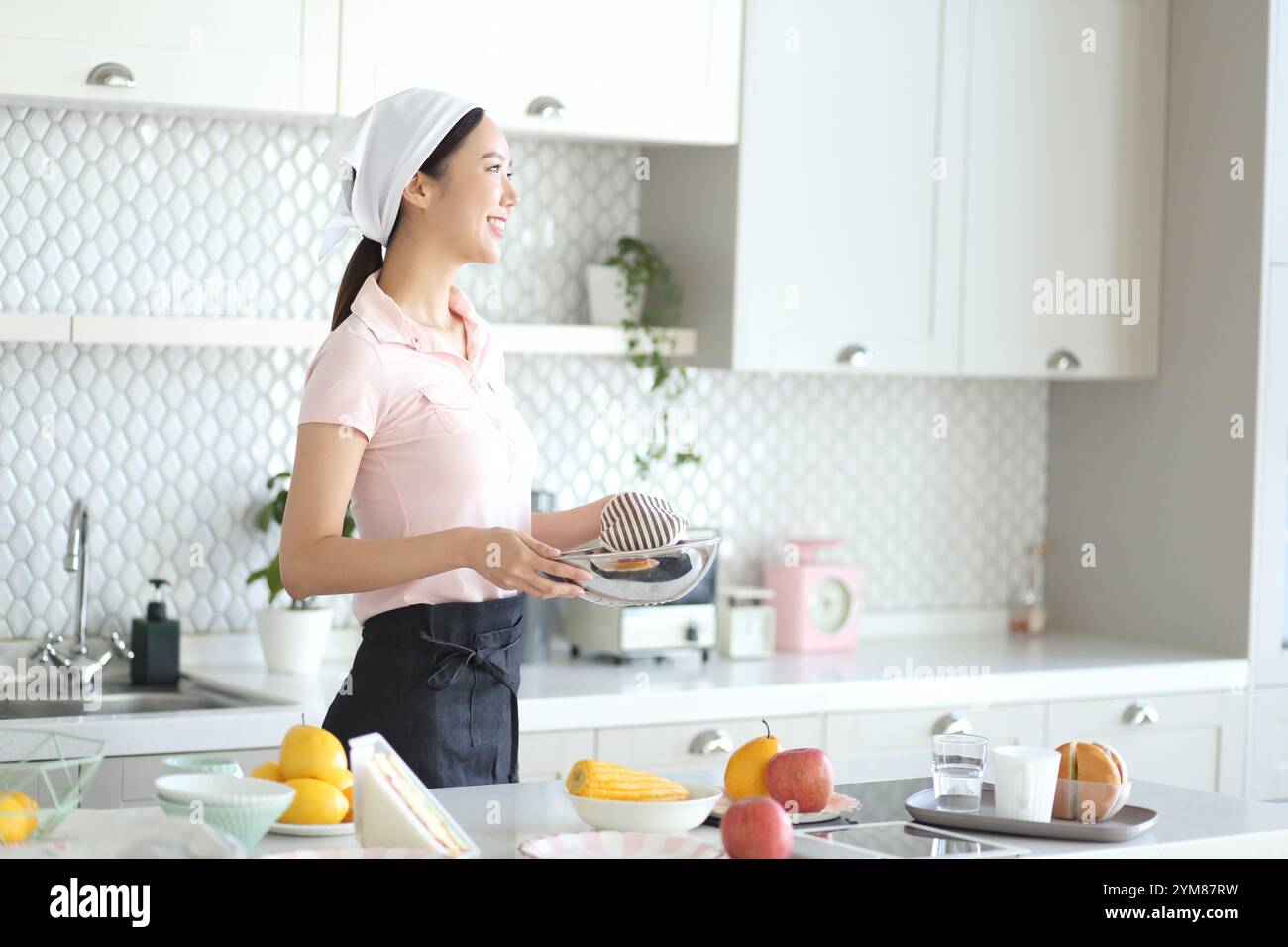 Woman cooking in the kitchen with a smile Stock Photo - Alamy