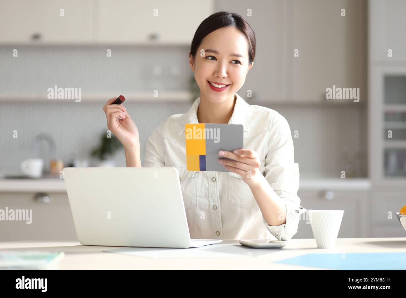 Young woman holding her personal seal and bank passbook with a smile ...