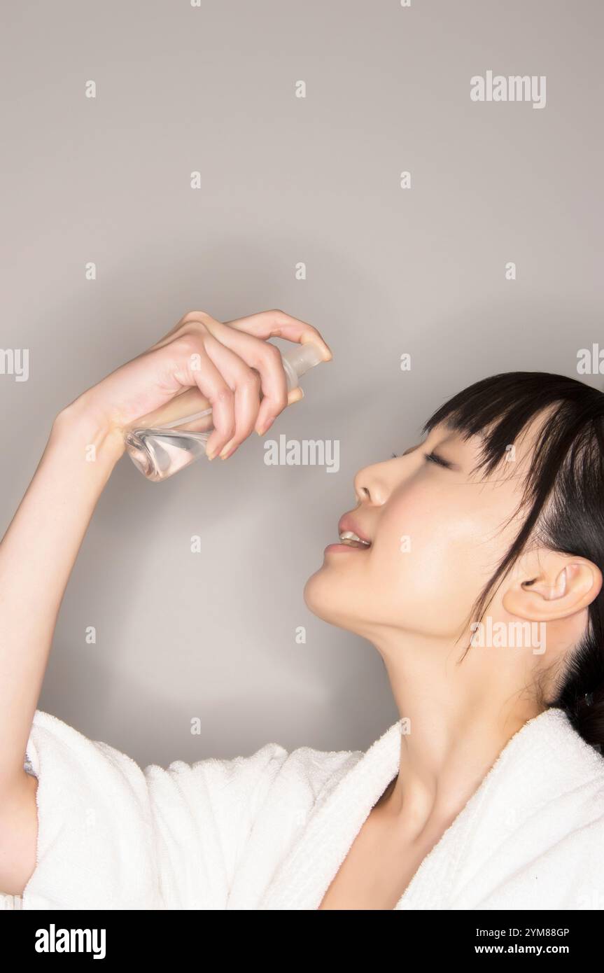 Woman using water spray Stock Photo - Alamy