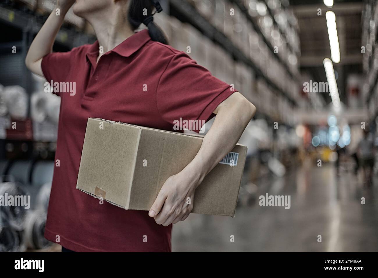 Woman carrying a box of goods at a logistics warehouse Stock Photo - Alamy