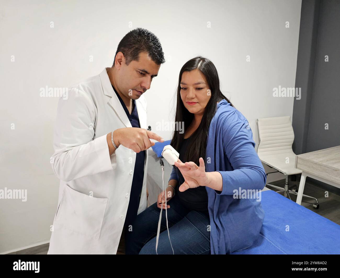 Male brunette specialist doctor gives consultation to his woman patient ...