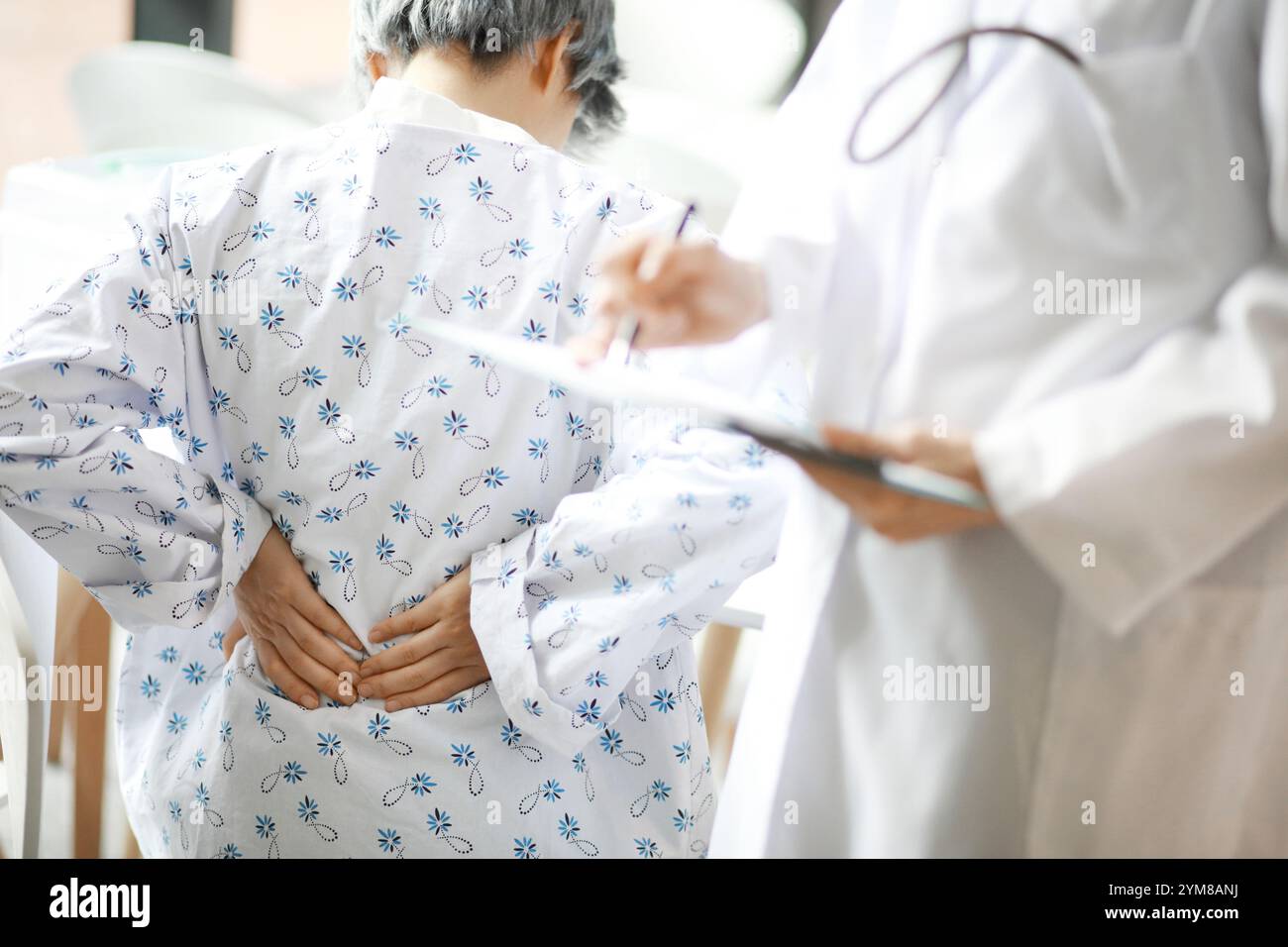 Female doctor treating a patient with a sore back Stock Photo - Alamy