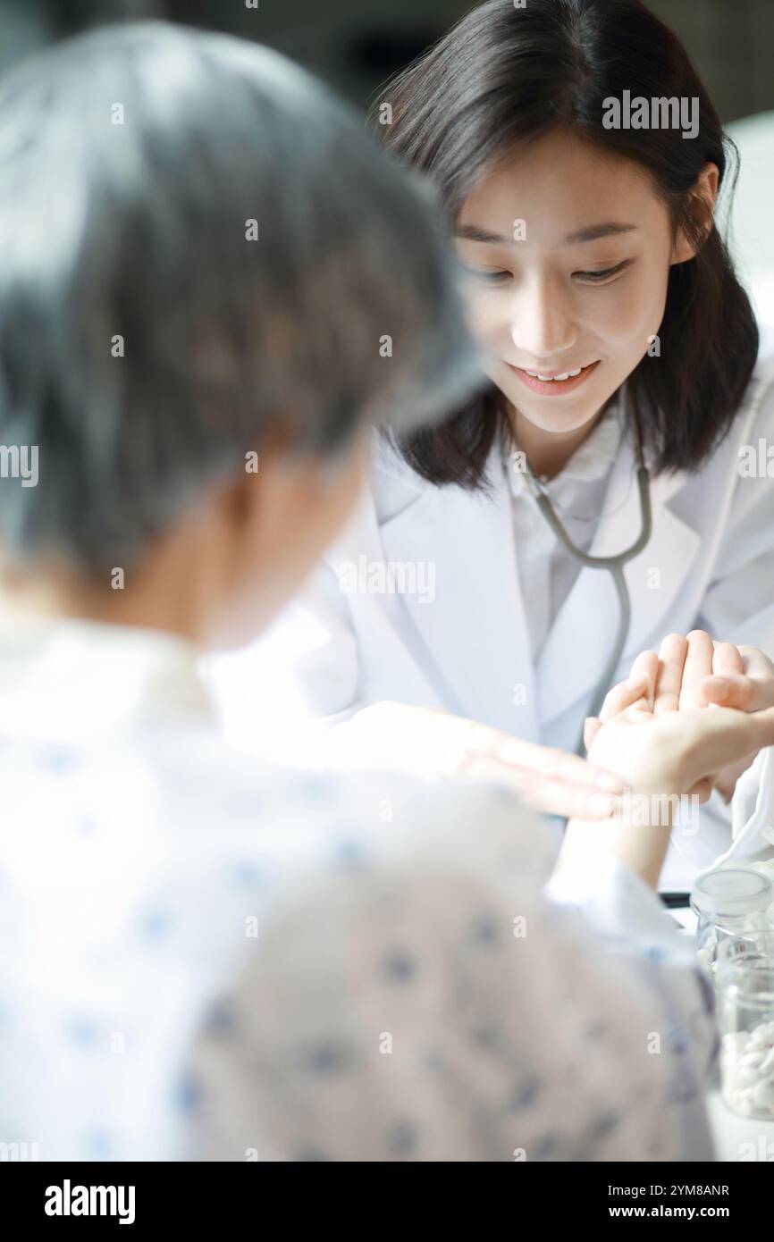 Female doctor examining a patient with a smile Stock Photo - Alamy