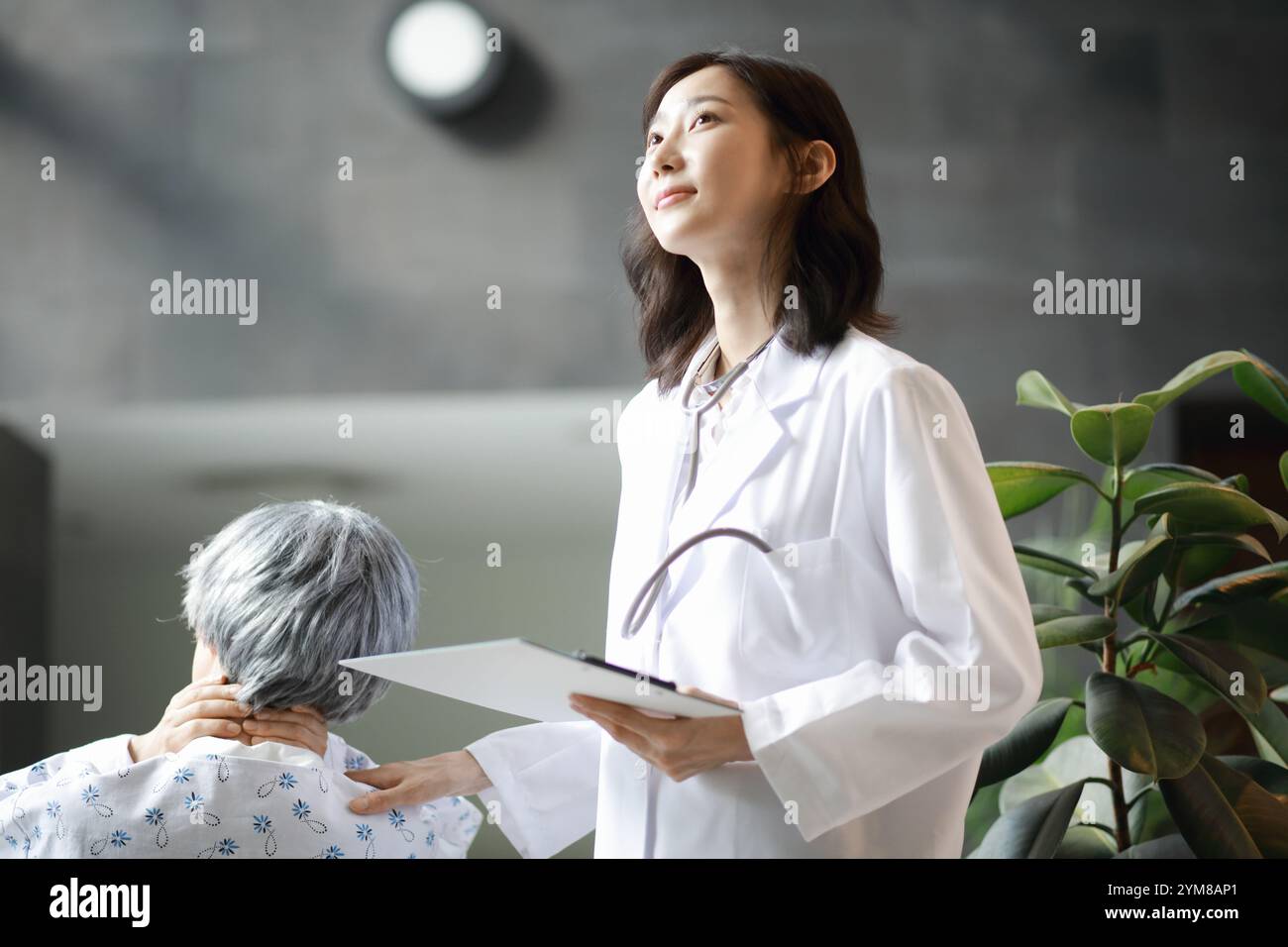Female doctor and patient holding chart Stock Photo - Alamy