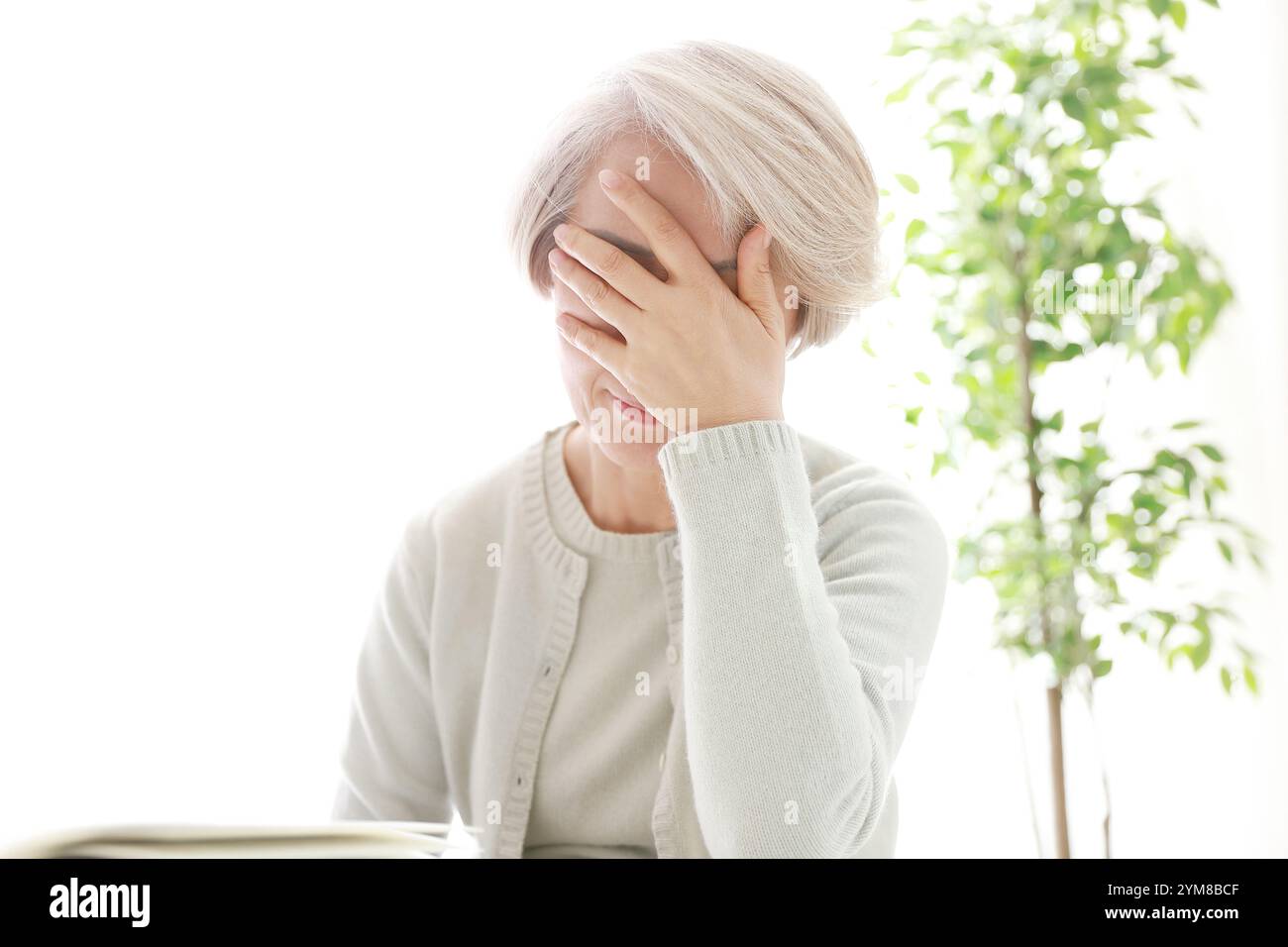 Old woman covering her eyes with her left hand Stock Photo - Alamy