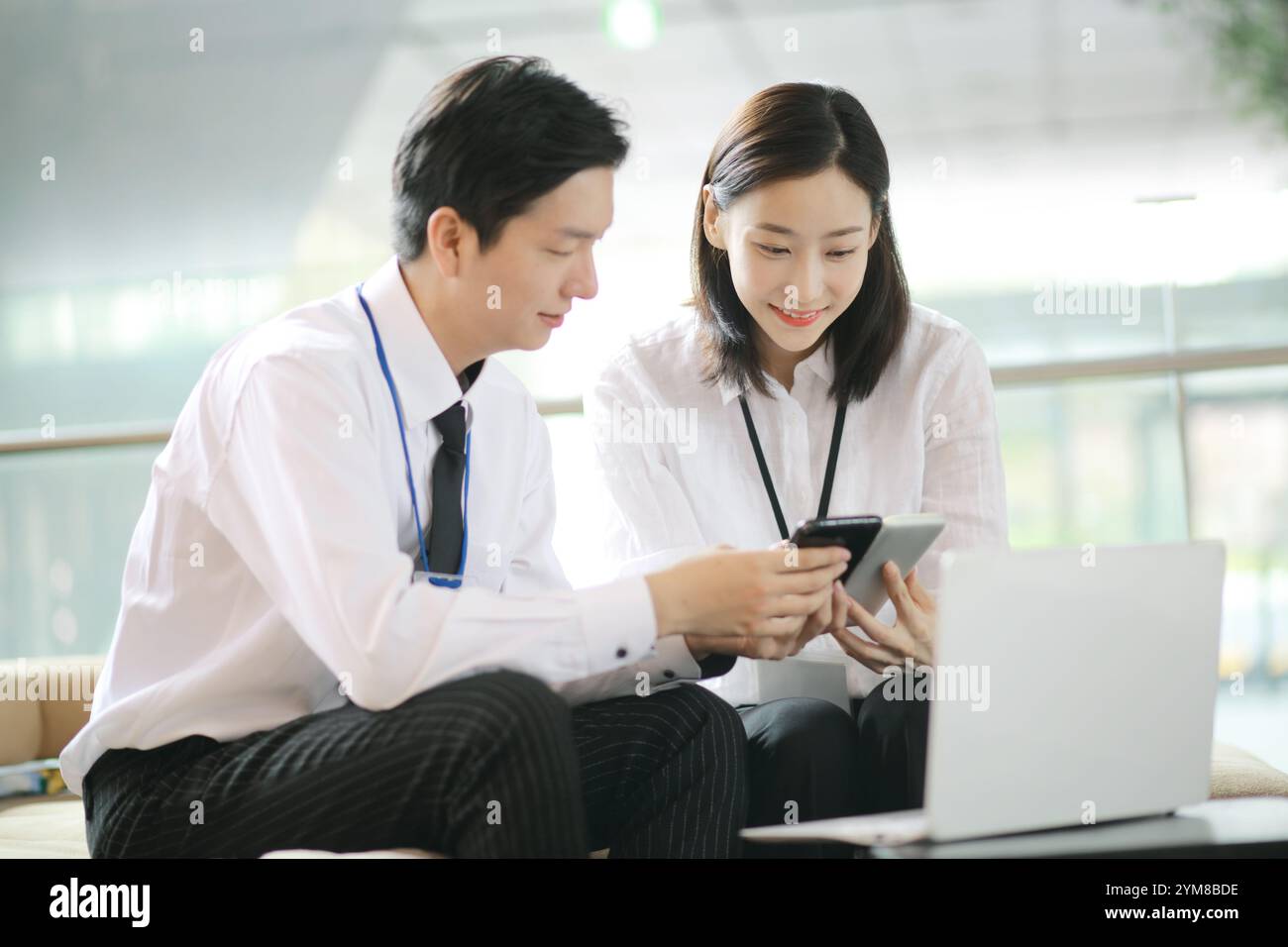 Salesman and female office worker with smartphone in hand Stock Photo ...