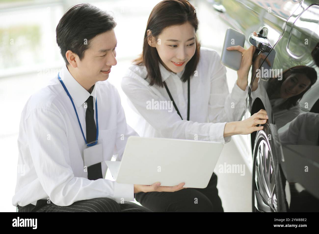 Female saleswoman selling a car with a smile Stock Photo - Alamy
