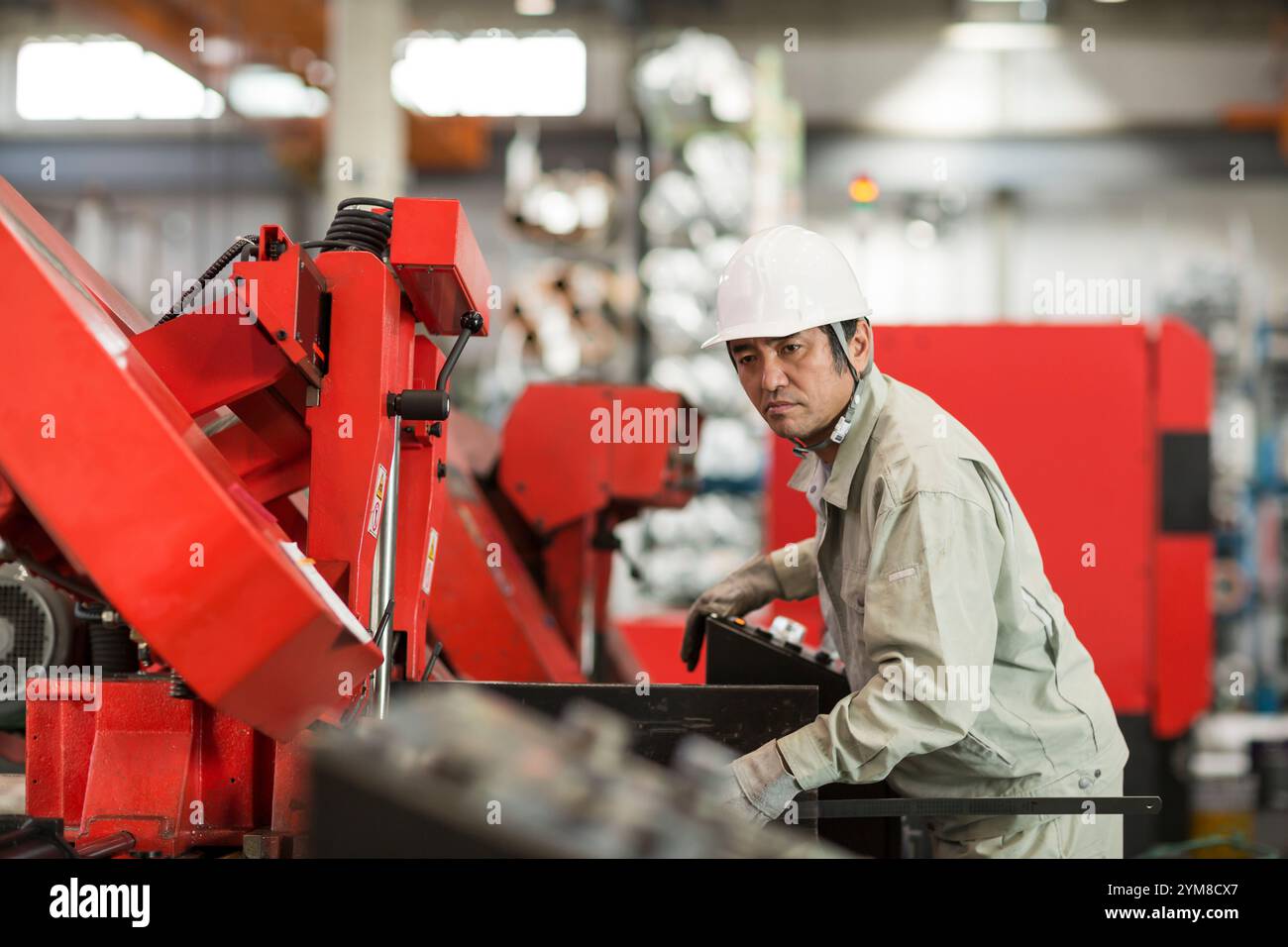 Man in work clothes operating a machine Stock Photo - Alamy