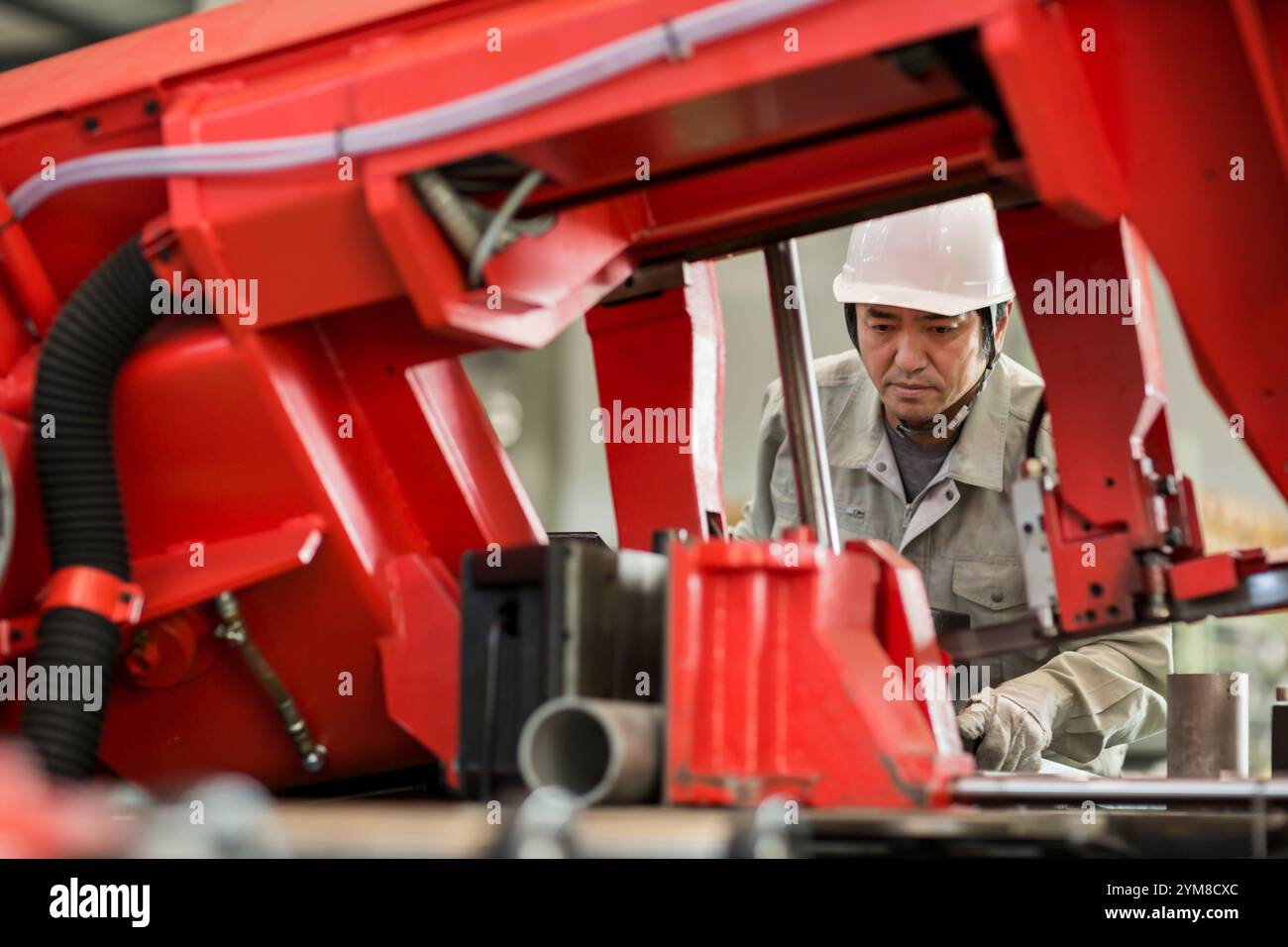Man in work clothes operating a machine Stock Photo - Alamy