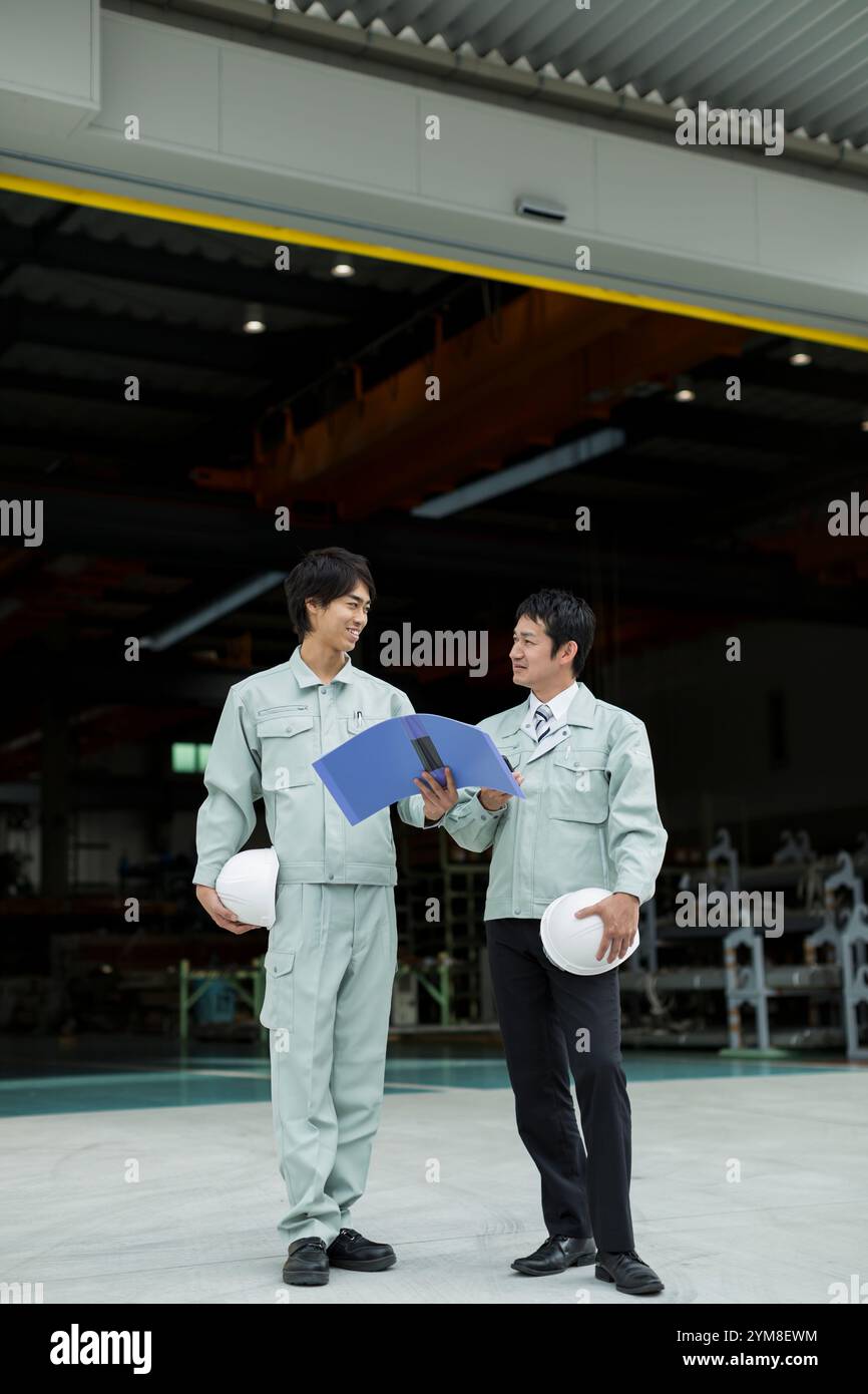 Two men in work clothes having a meeting Stock Photo - Alamy