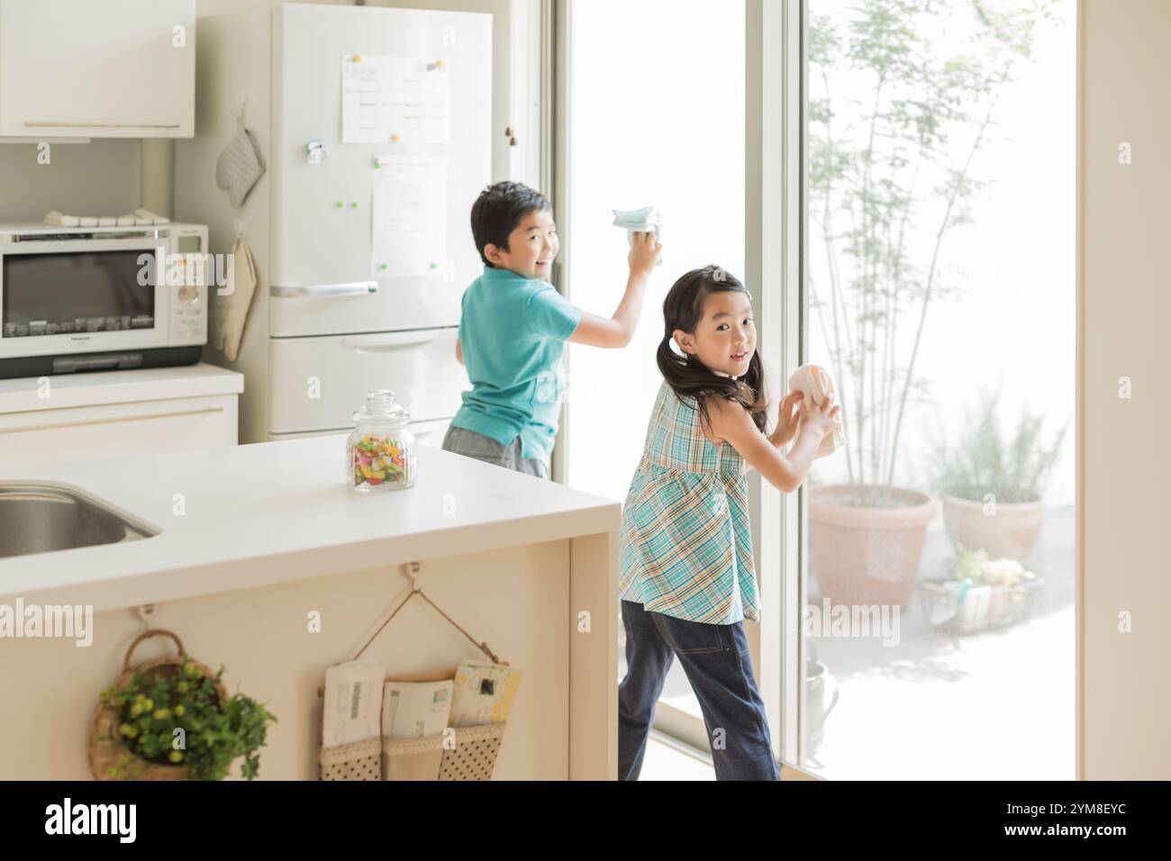 Brother and sister cleaning window Stock Photo - Alamy