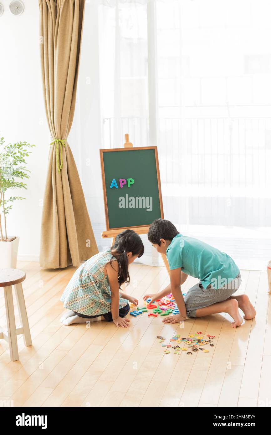 Brother and sister playing with alphabet Stock Photo - Alamy