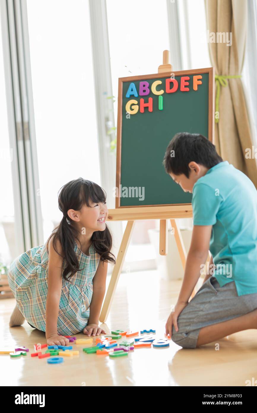 Brother and sister playing with alphabet Stock Photo - Alamy