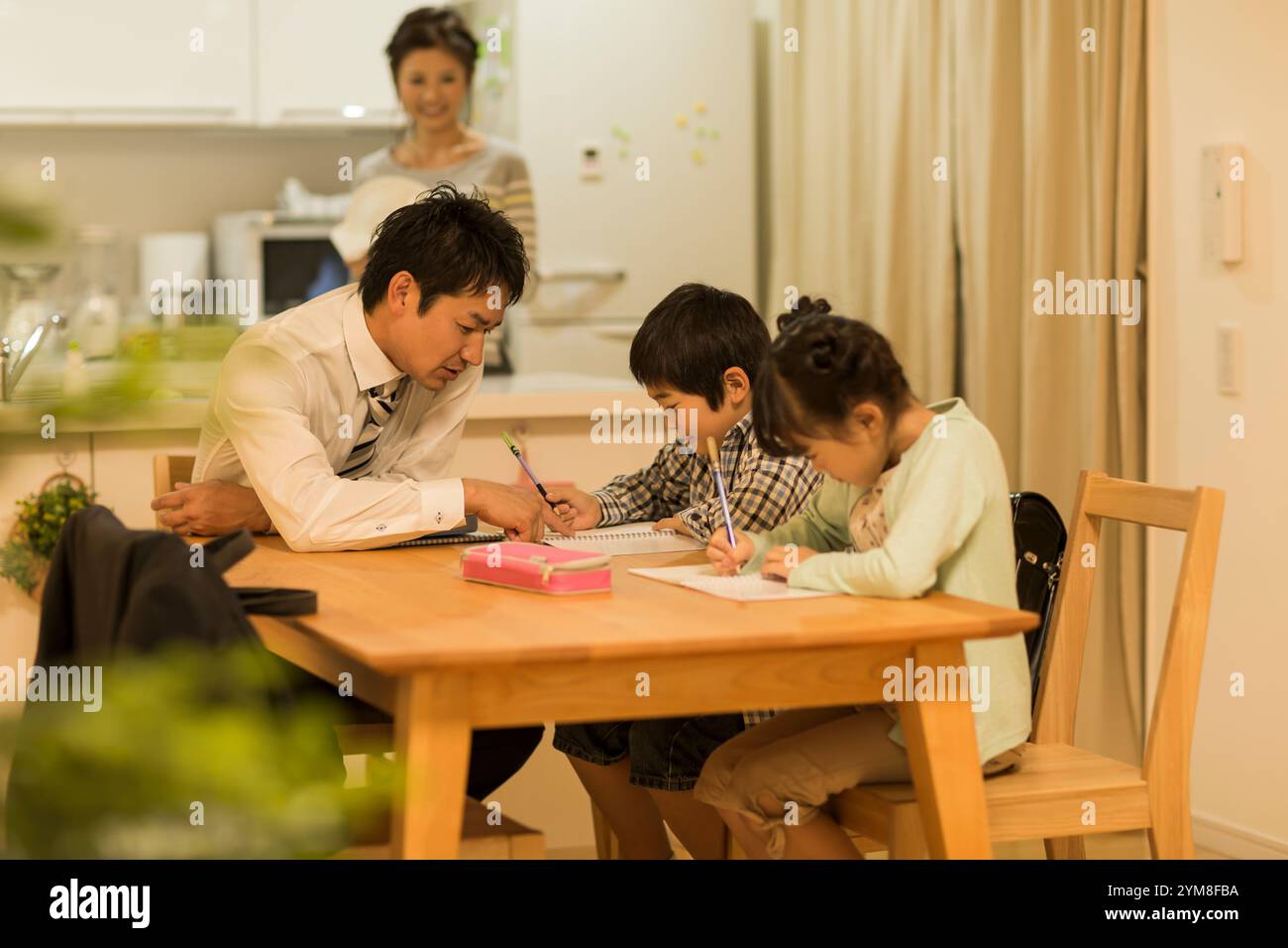 Father watching children studying Stock Photo - Alamy